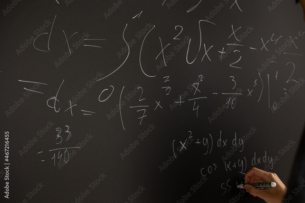 Person witting mathematic equation on chalkboard Stock Photo | Adobe Stock