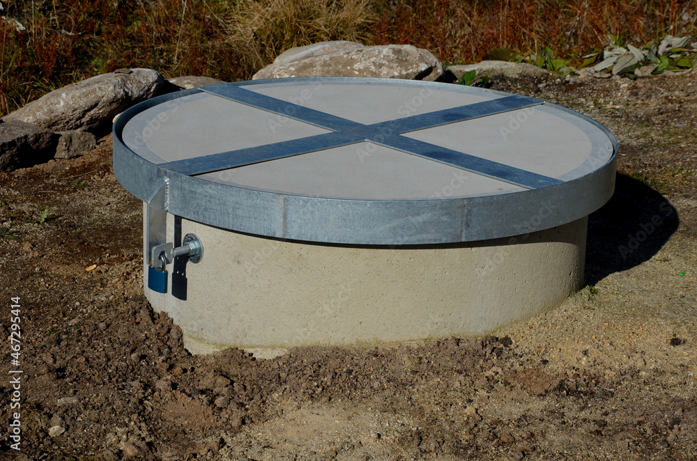 concrete well well covered with a round concrete lid. a fall into a ...