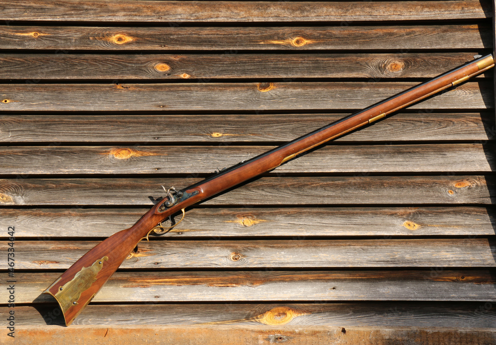 Kentucky black powder rifle on the background of an old wall of boards ...