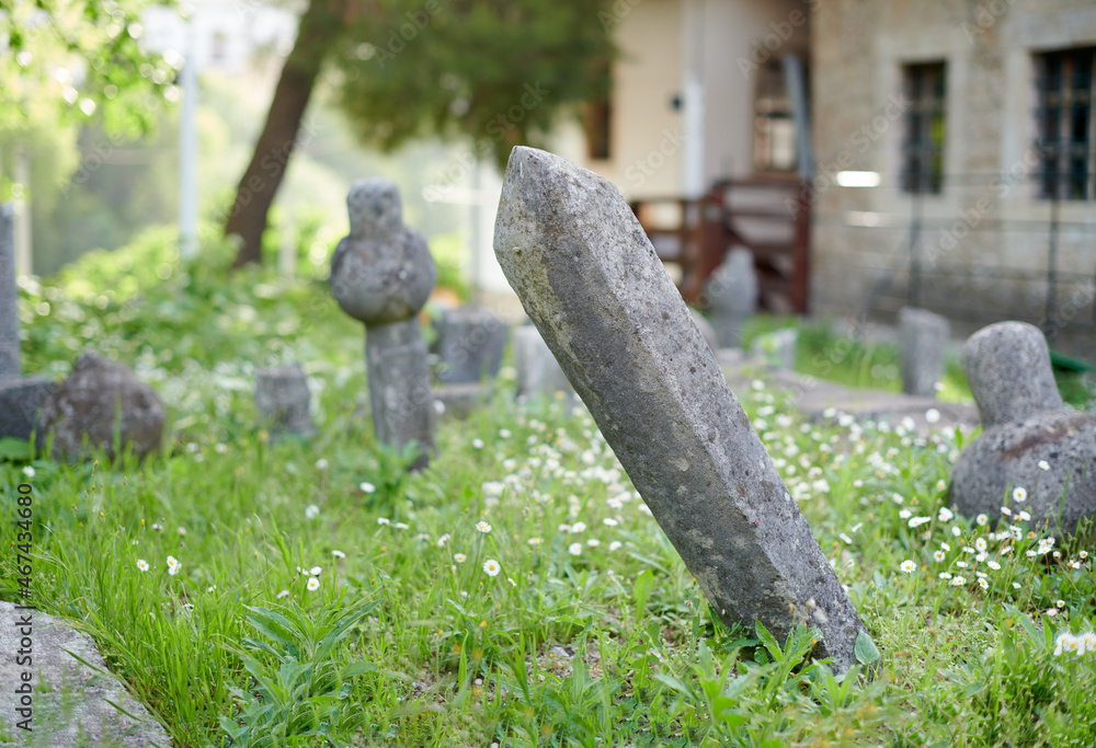 Ancient Muslim cemetery. Traditional stone gravestones. Blurred green ...