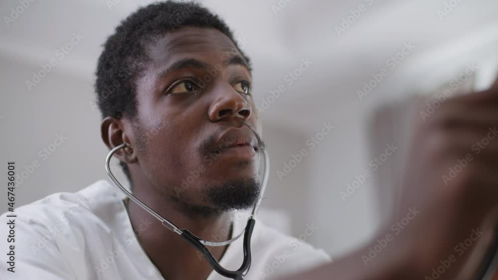 Video Stock Close-up focused African American doctor auscultating heart ...