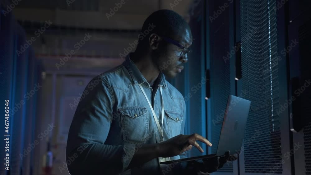 Engineer serving of contemporary data center. African-American person ...