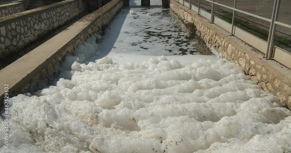 Water pollution. Pollution of a channel caused by surfactants.White ...