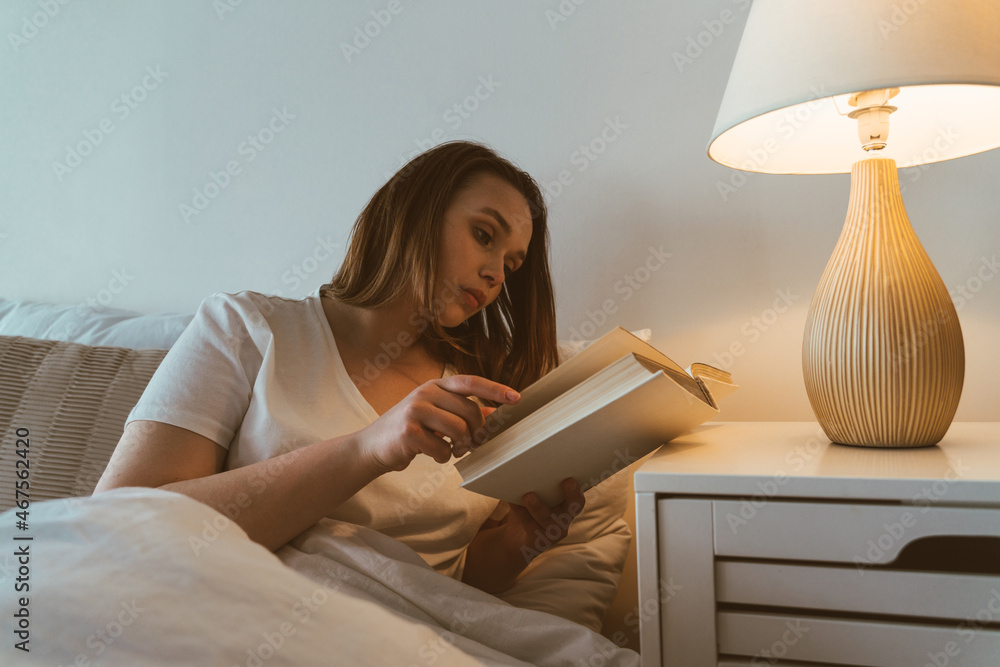 Woman reading before going to sleep Stock-Foto | Adobe Stock