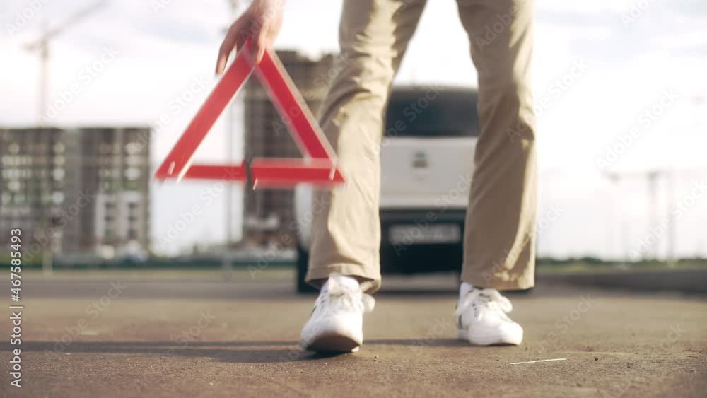 Man driver placing warning triangle on road going to repair flat tire ... Man driver placing warning triangle on road going to repair flat tire ...