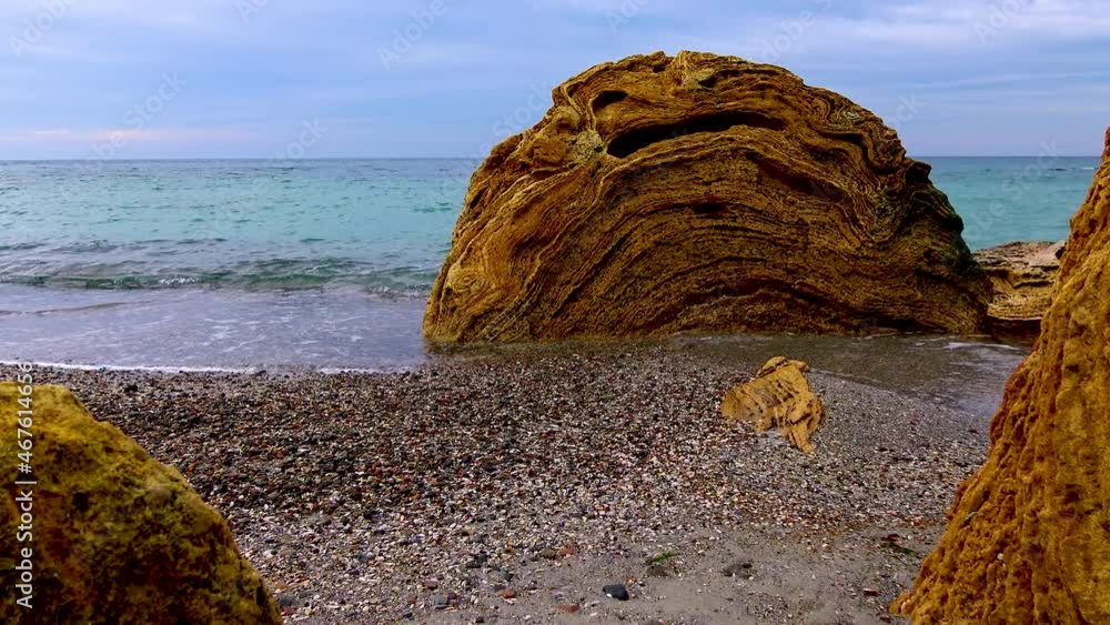 Shell rock with curved layers on a beach by the sea, geological ...