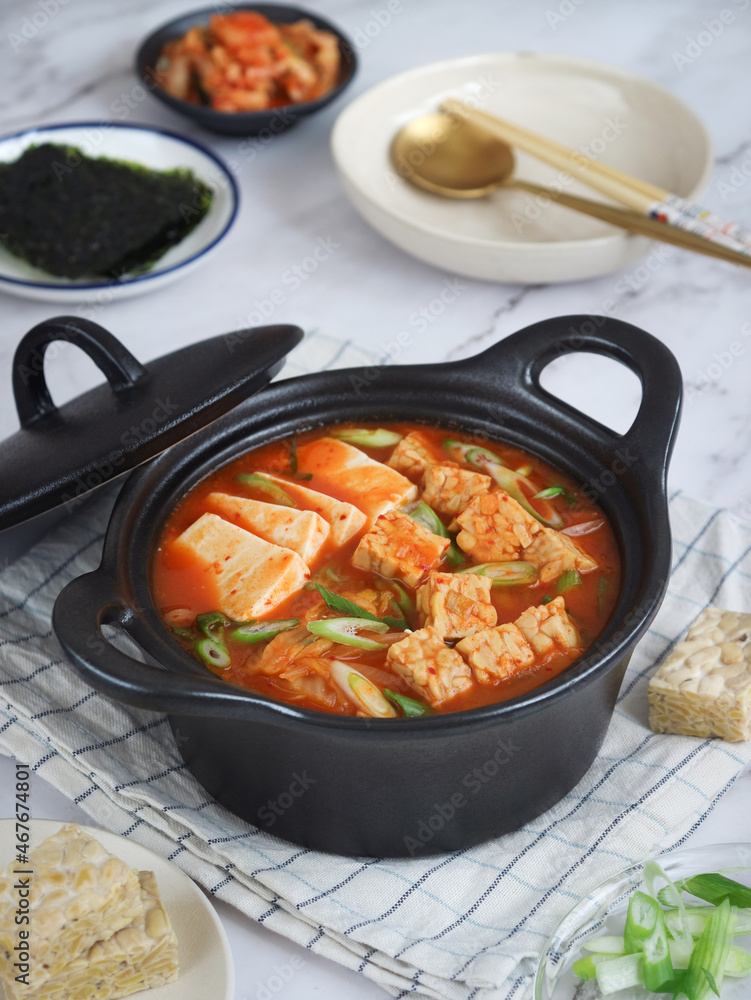A bowl of hot vegan spicy Korean kimchi stew soup (kimchi jigae) with ...