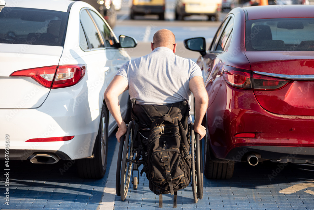 Person with a physical disability getting in red car fom wheelchair ...