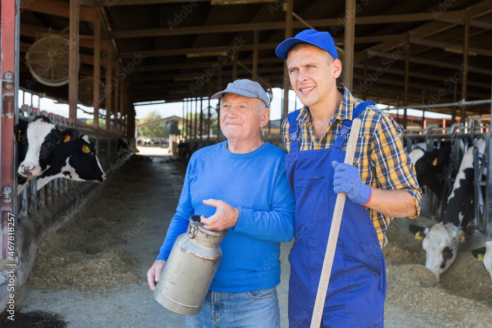 Successful elderly dairy farm owner with adult son posing together ...