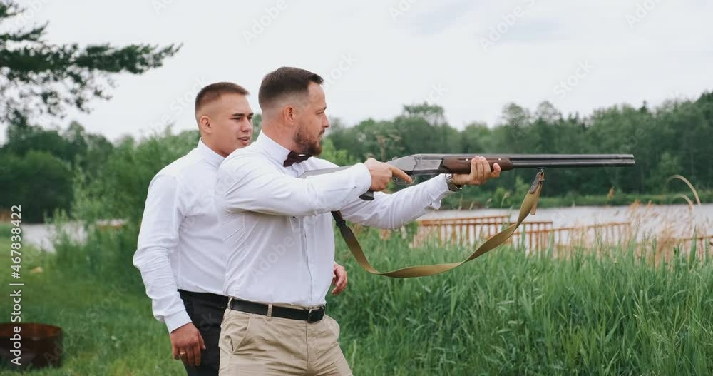Two men friends shooting the gun, a strong shot with recoil. Guys have ...