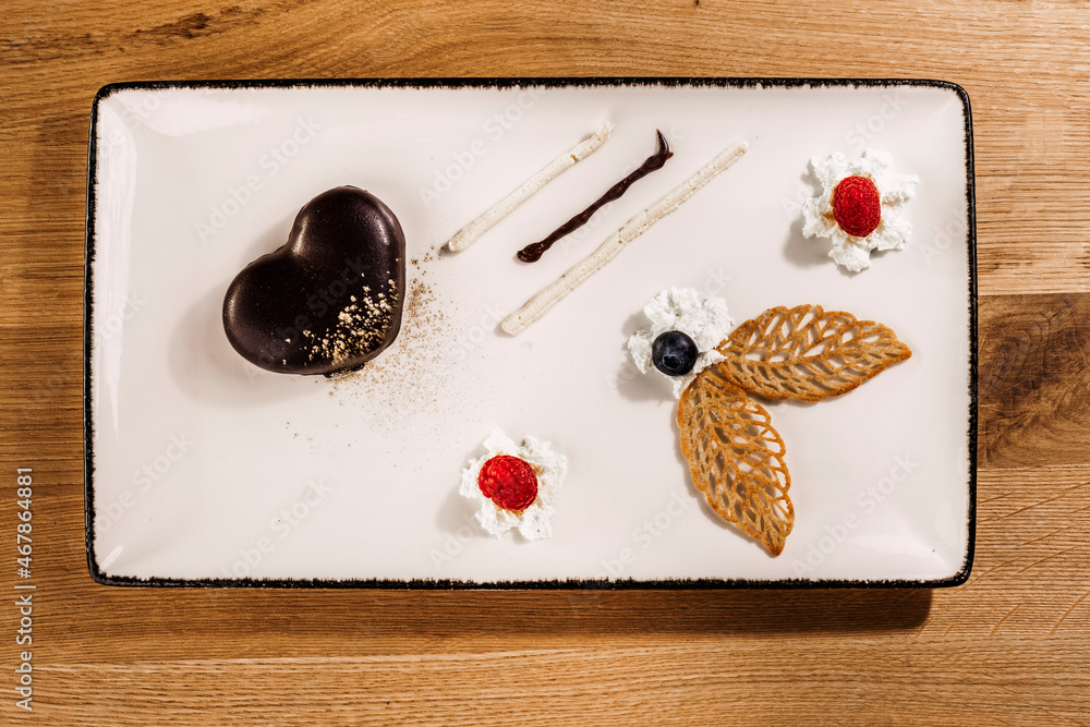 Studio shot of tray with finely presented chocolate cake with fruit and ...