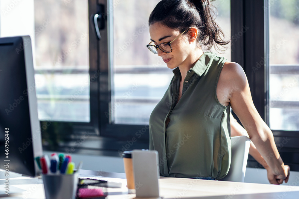 Tired businesswoman stretching body for relaxing while working with ...