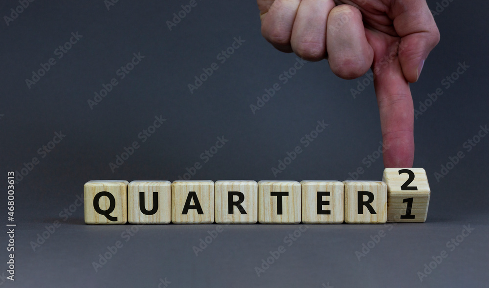 From 1st to 2nd quarter symbol. Businessman turns a cube and changes ...