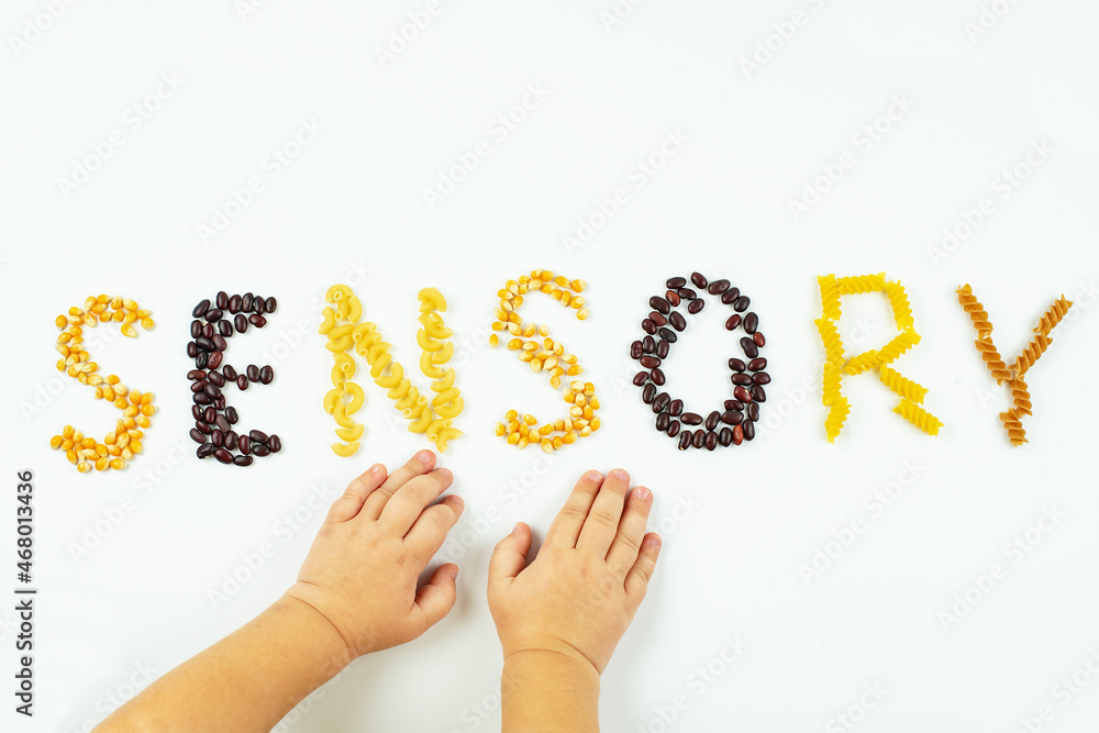 Sensory word written of popcorn, beans, pasta and children hands ...