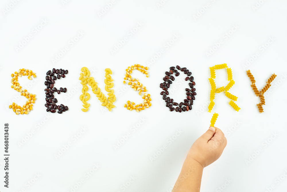 Sensory word written of popcorn, beans, pasta and children hands ...