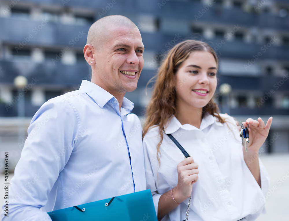Happy married couple standing near building under construction. Wife ...