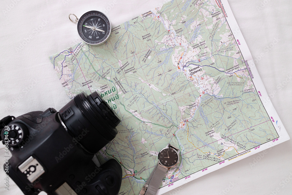 Camera, magnetic compass and clock on the world map. Adventure ...