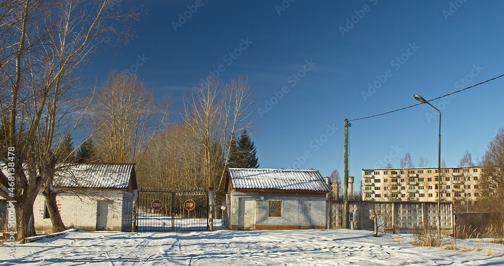 Closed metal gate with stop sign and guard houses in sunny winter day ...