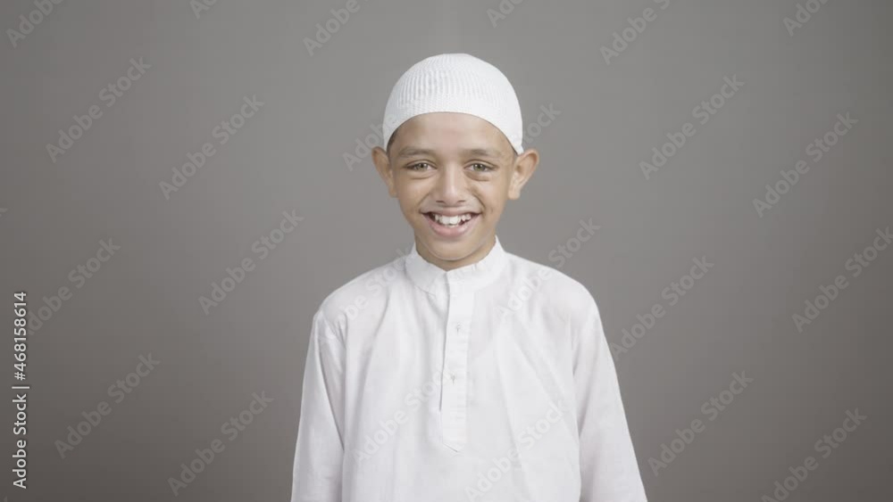 Stockvideo smiling Muslim child with traditional cap by looking at ...