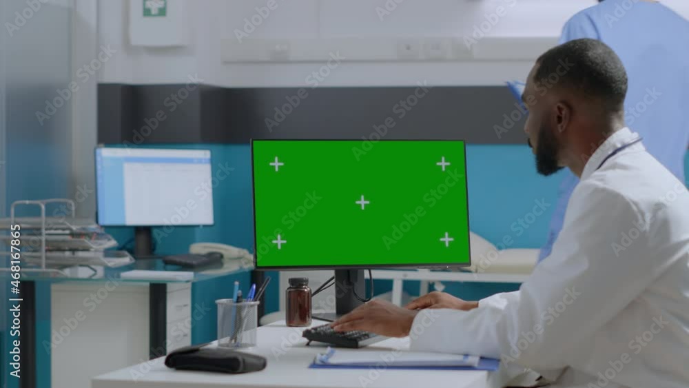 African american physician doctor looking at mock up green screen ...