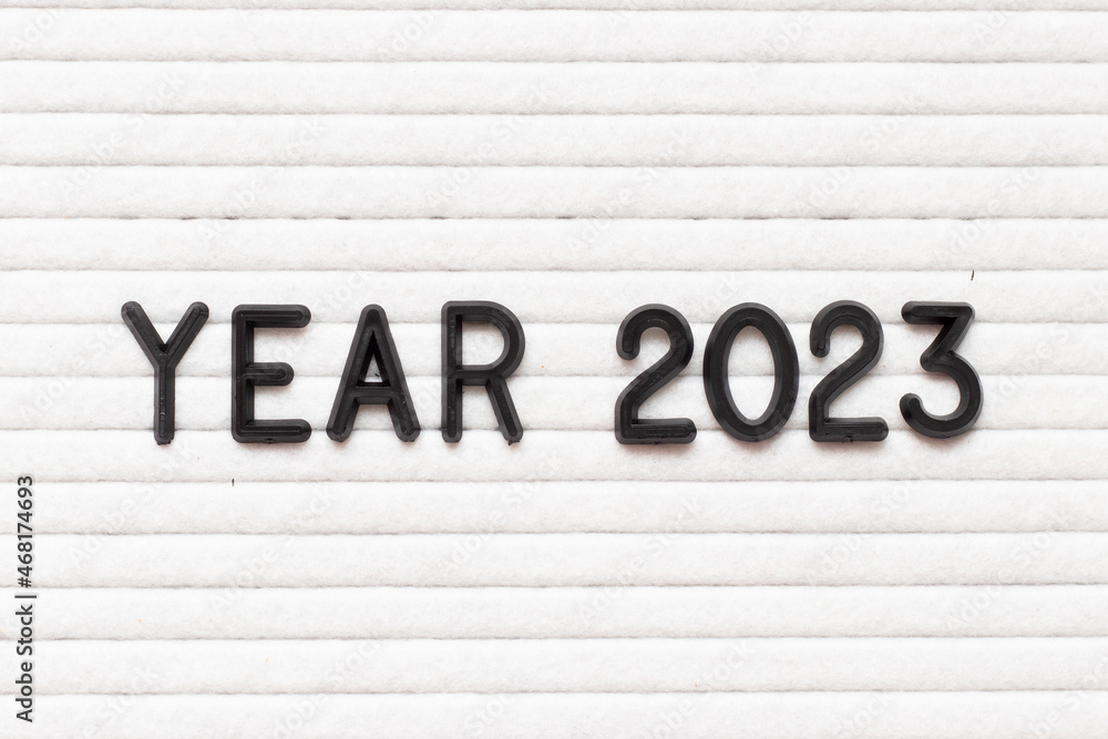 Black color letter in word year 2023 on white felt board background ...