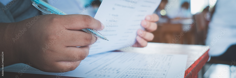 Students writing and reading exam answer sheets exercises in classroom ...