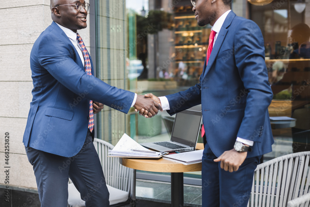 Portrait of two black African American businessmen in suits shaking ...