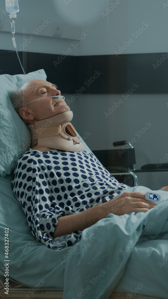Old patient with cervical neck collar laying in hospital ward bed at ...