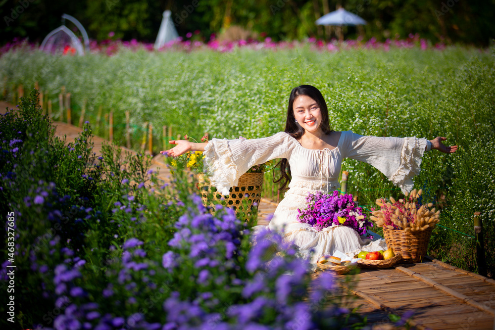 Beautiful asian girl Taking pictures in a flower farm. Happily in ...