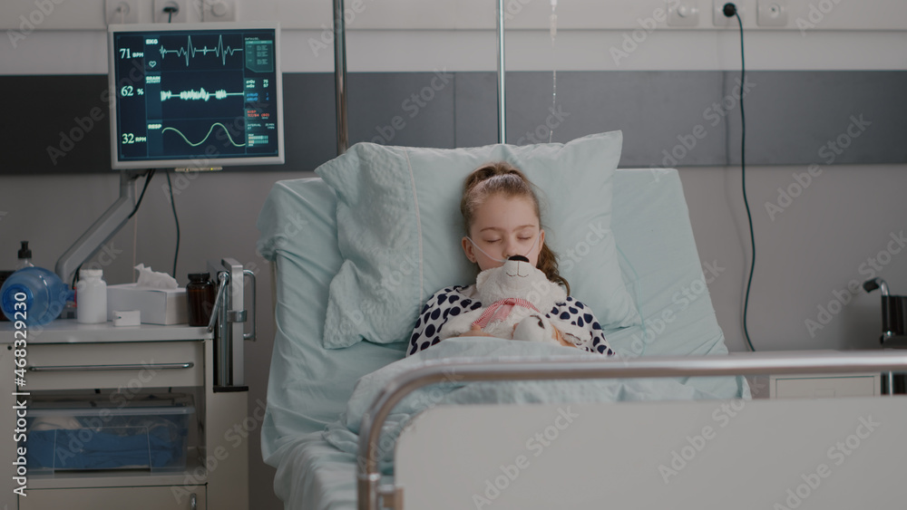 Portrait of hospitalized sick child falling asleep while holding teddy ...