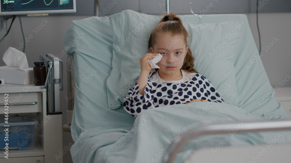 Portrait of sick vulnerable alone little child looking into camera ...