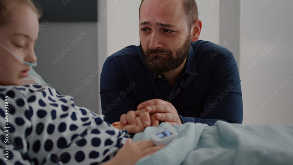 Worried sad father crying beside sick daughter waiting for healthcare ...