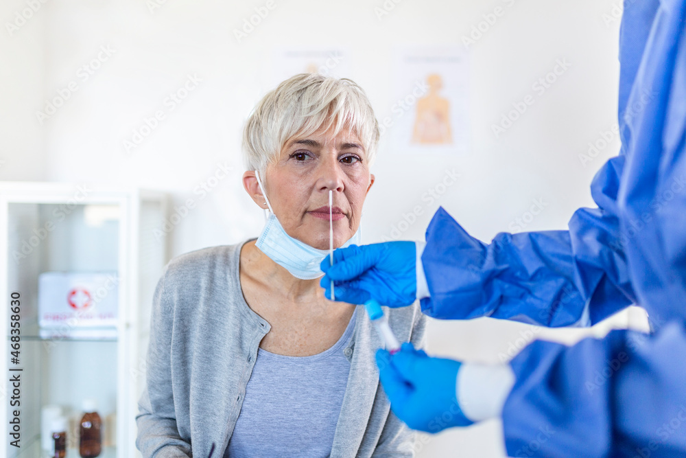 Physician wearing personal protective equipment performing a ...