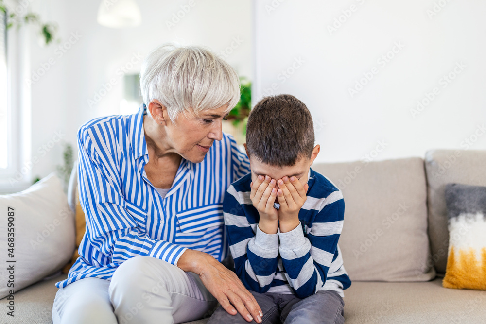 Loving understanding old grandma embracing little crying boy comforting ...