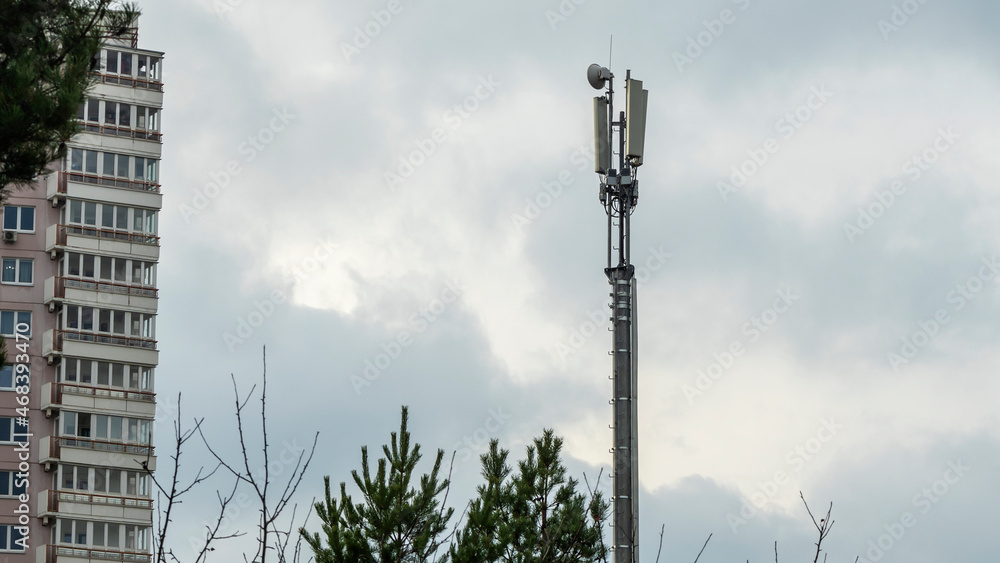 Tower with mobile operator antennas on the dramatic sky background ...