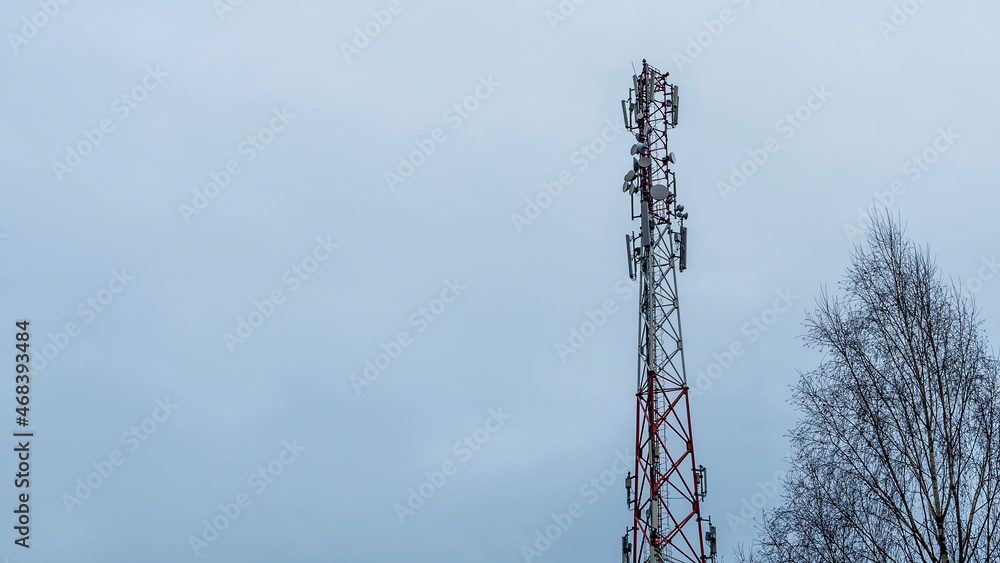Tower with mobile operator antennas on the dramatic sky background ...
