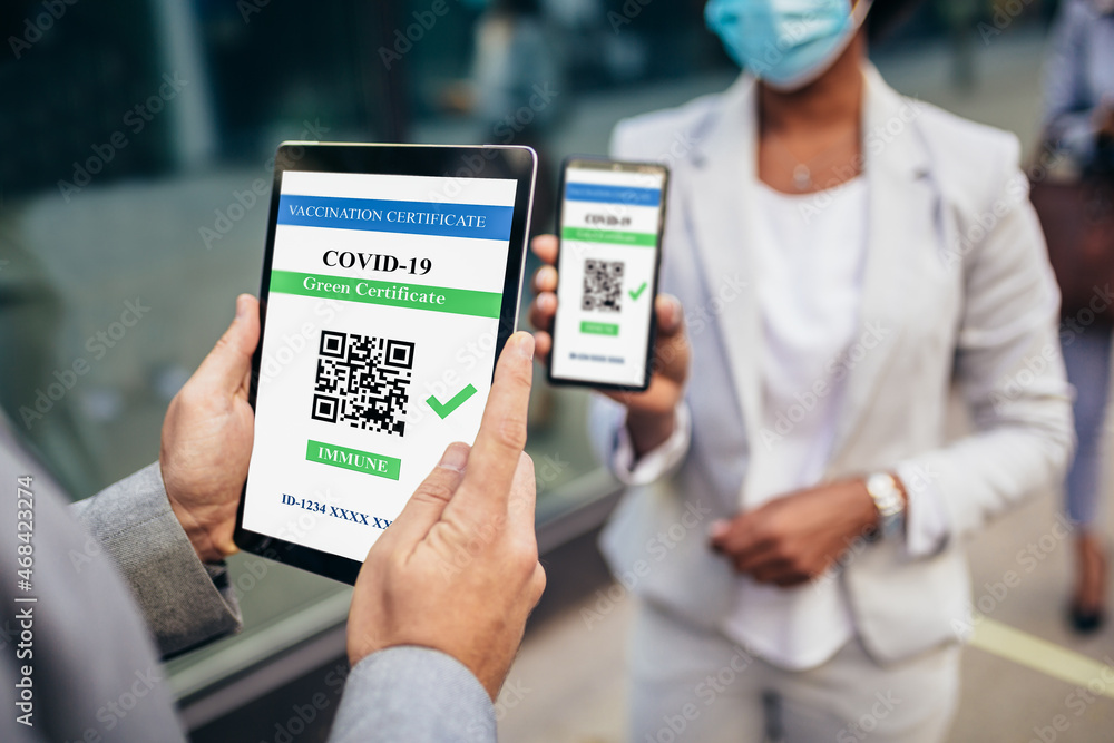 Business woman in safety mask showing electronic vaccination ...