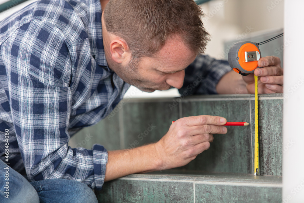 worker using tape measure on riser and thread on stairs Stock Photo ...