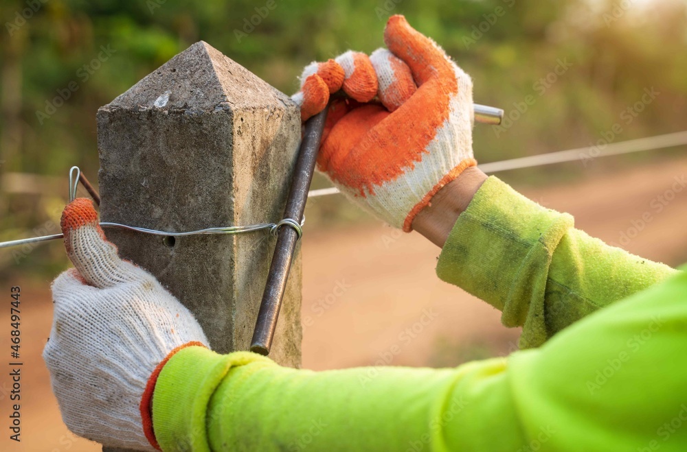 Agriculture farmers wear gloves work by hand installation of wire ...