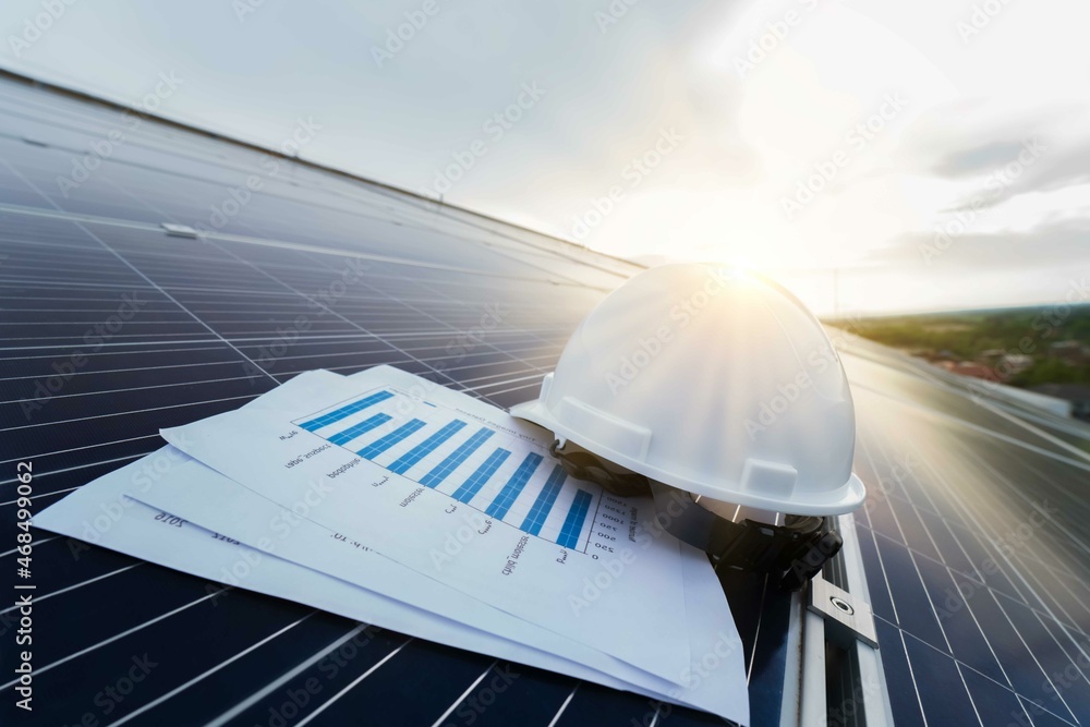 White safety helmet and check chart on the solar cell board.Natural ...