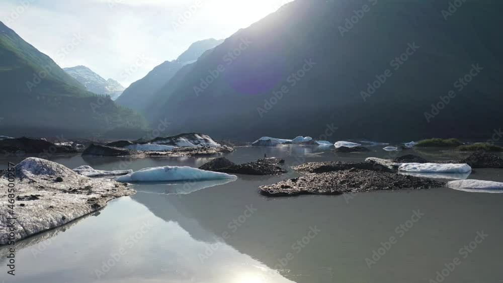 Valdez glacier lake melting in the summer with a paddleboarder floating ...