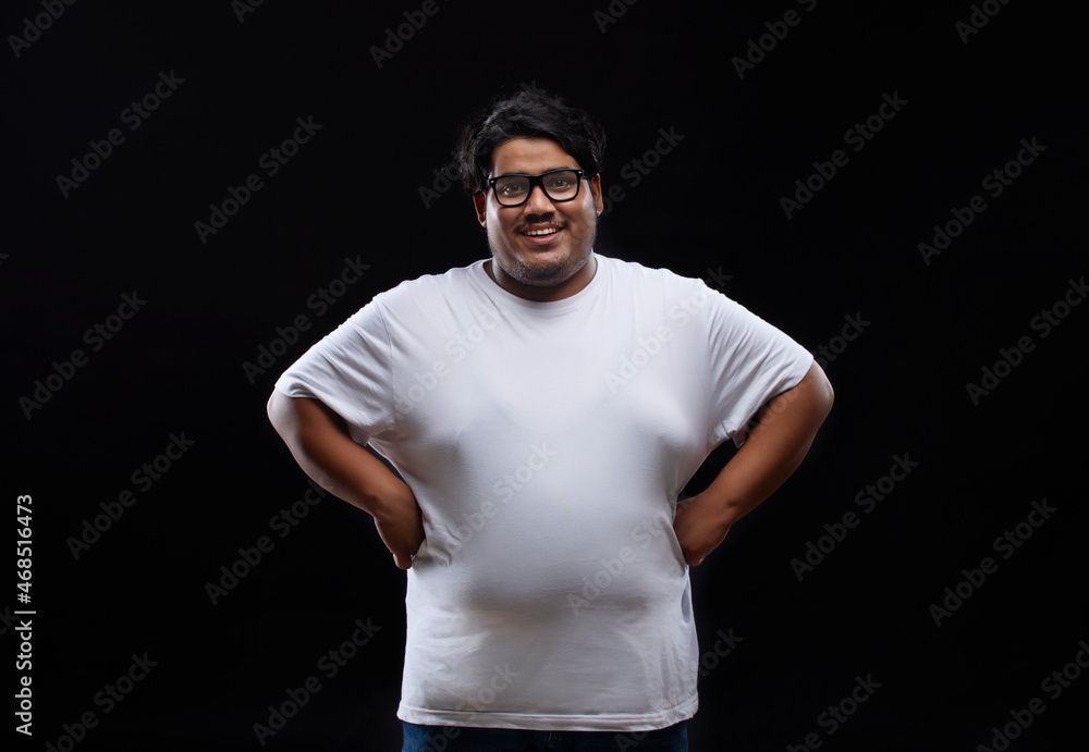 Portrait of a fat man smiling while placing hands on waist against ...