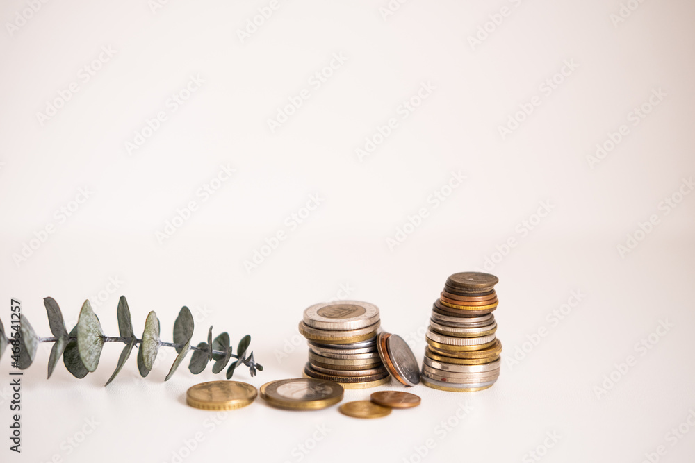 Money coins stacked on each other in different positions on a white ...