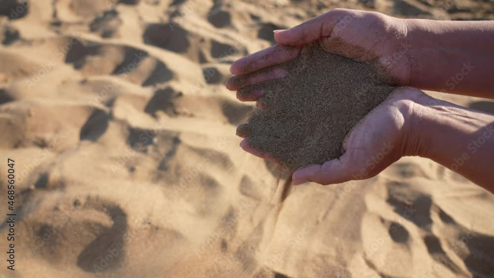 Close-up 4k slow motion video footage of golden sand in two cupped ...