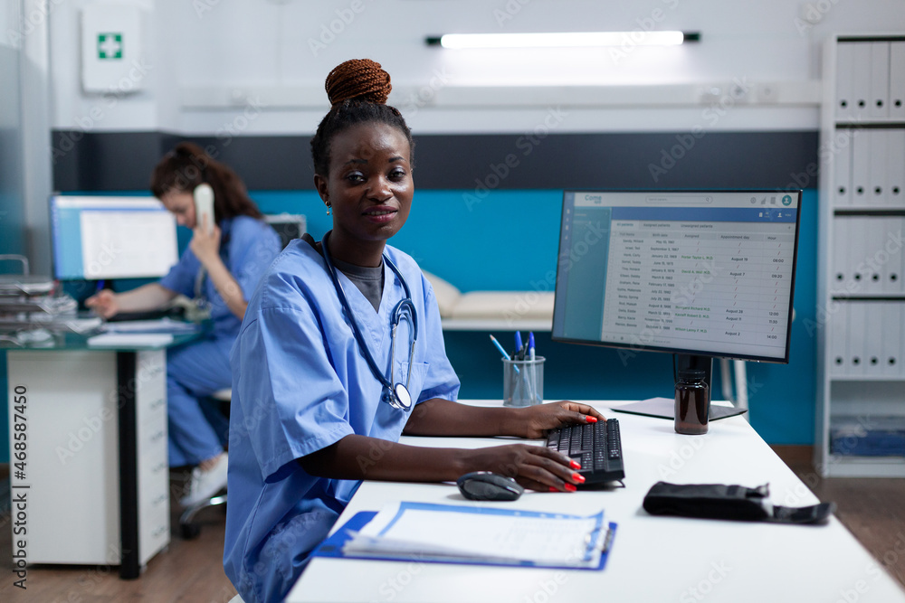 Portrait of african american pharmacist nurse typing medical ...