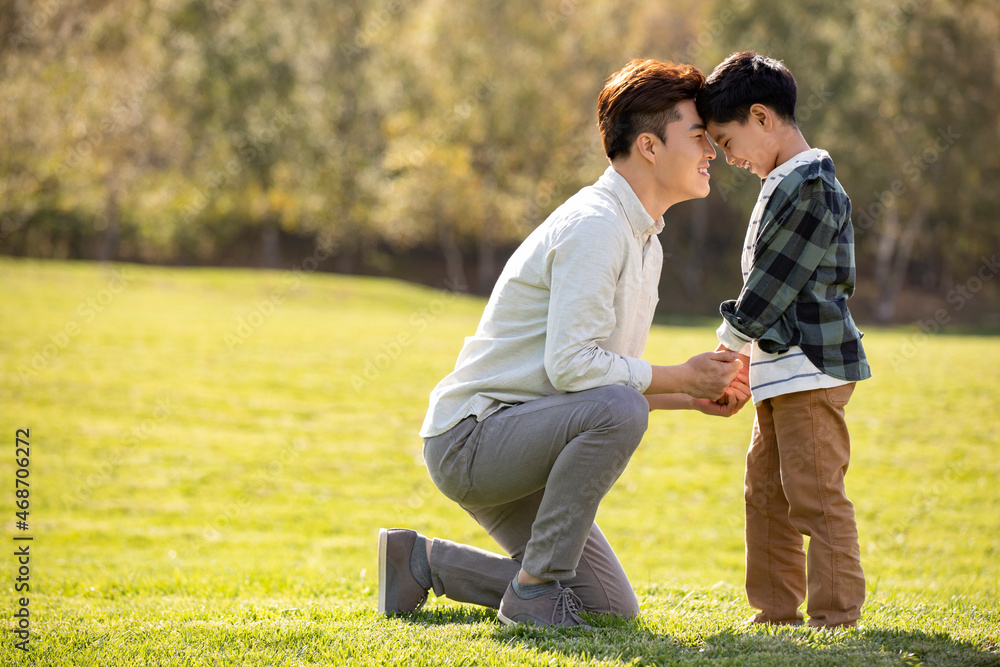 Happy Chinese father and son playing on meadow Stock Photo | Adobe Stock