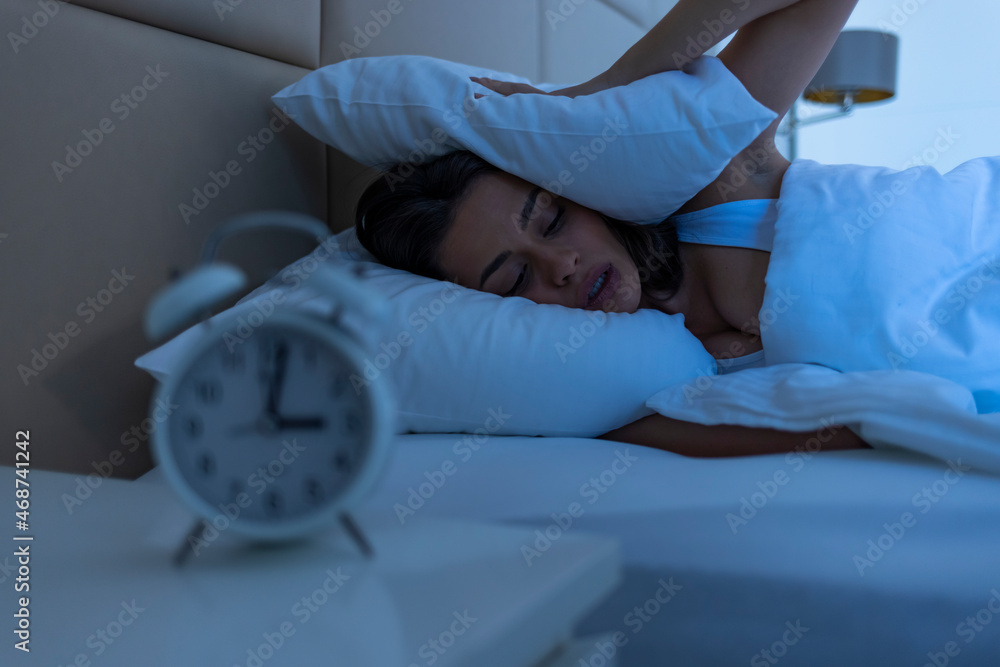 Depressed woman awake in the night, she is exhausted and suffering from ...