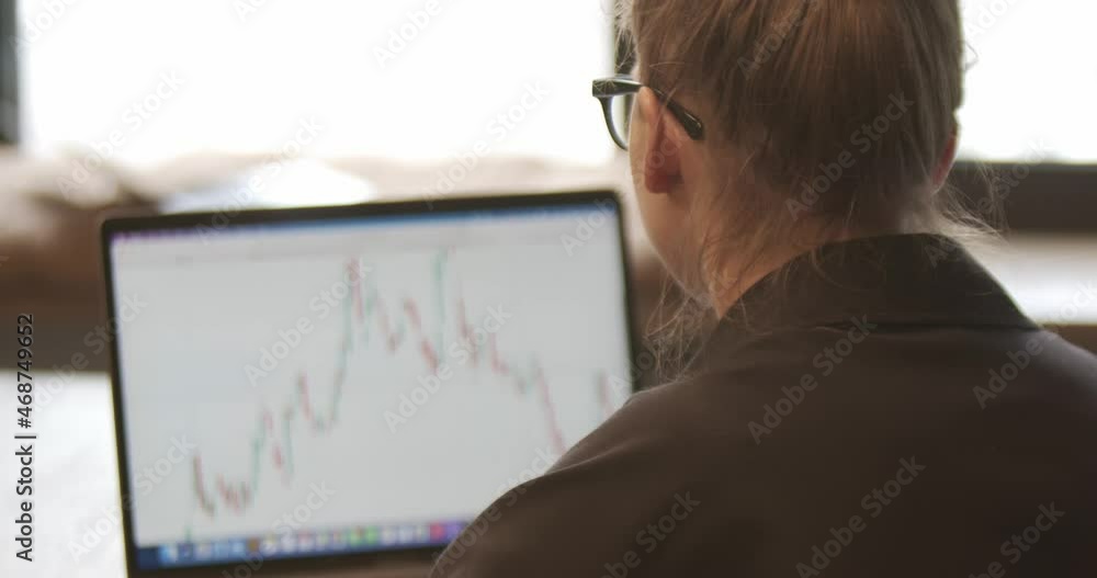 Woman back view with device, scrolling looking at the screen. Stock ...