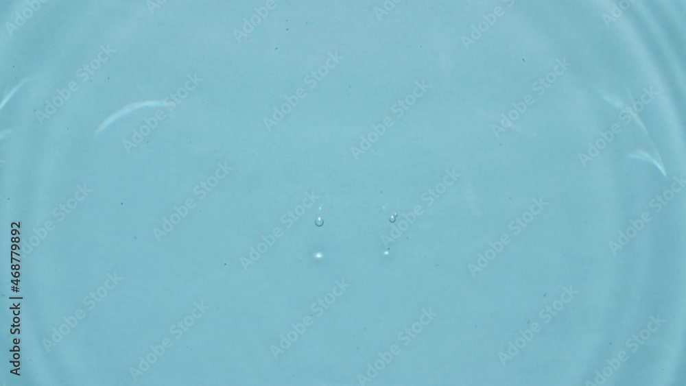 Top view slow motion of drop falls into water and diverging circles of ...