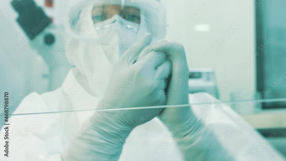 Handheld shot of a Caucasian female lab worker spraying a disinfectant ...